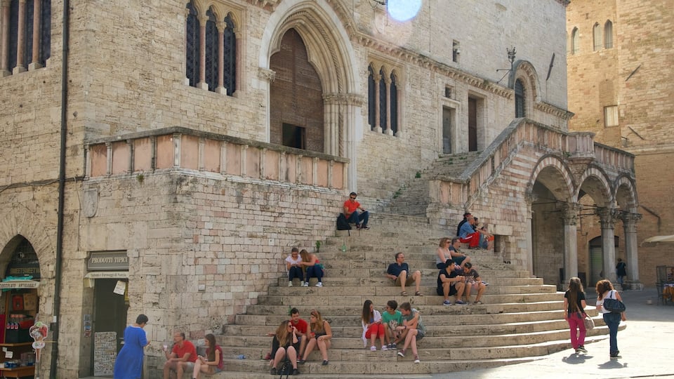 Palazzo dei Priori caracterizando arquitetura de patrimônio assim como um grande grupo de pessoas