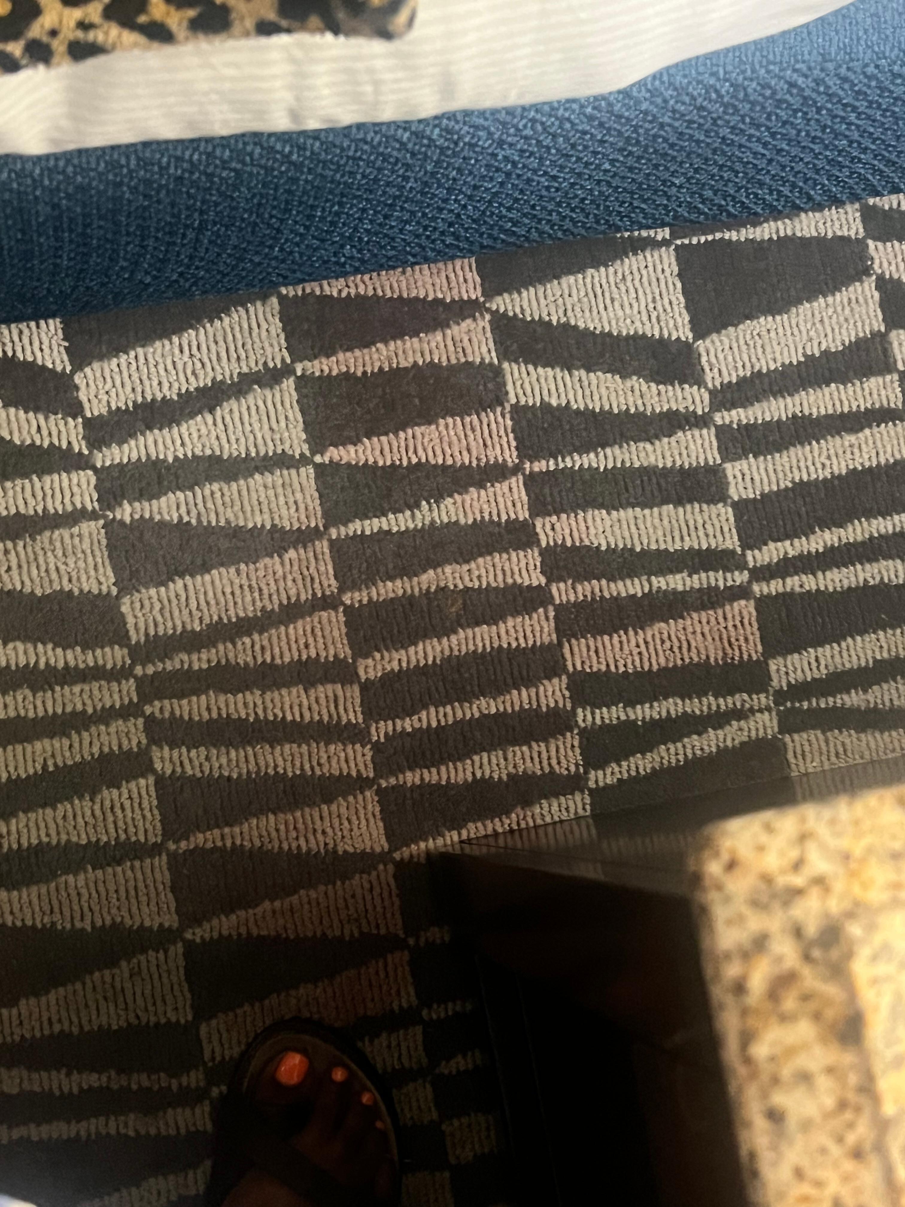 Red stains on carpet by bed 