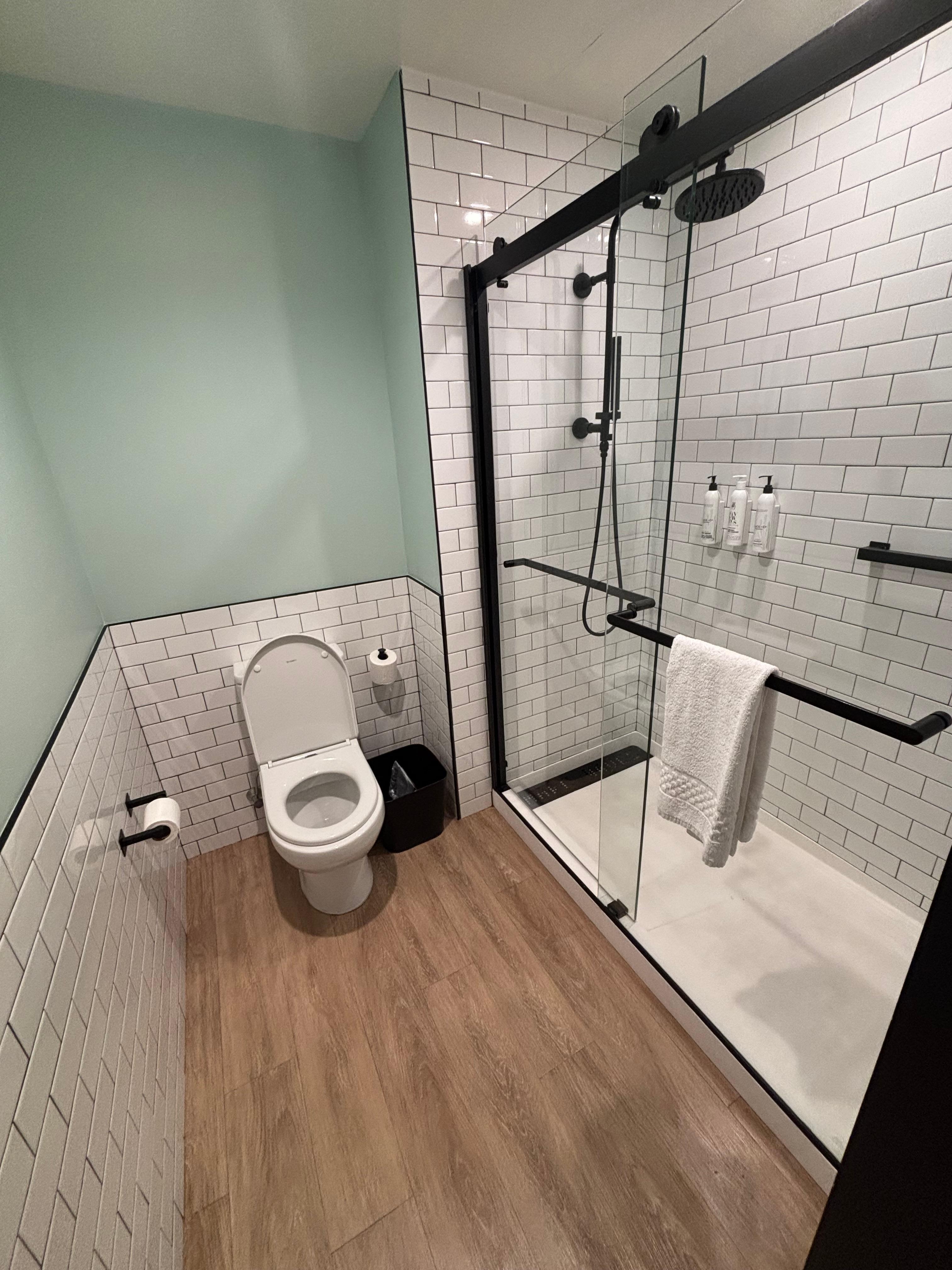 Modern bathroom with no sink or counter space but still nice. Rainfall showerhead. Low pressure. 