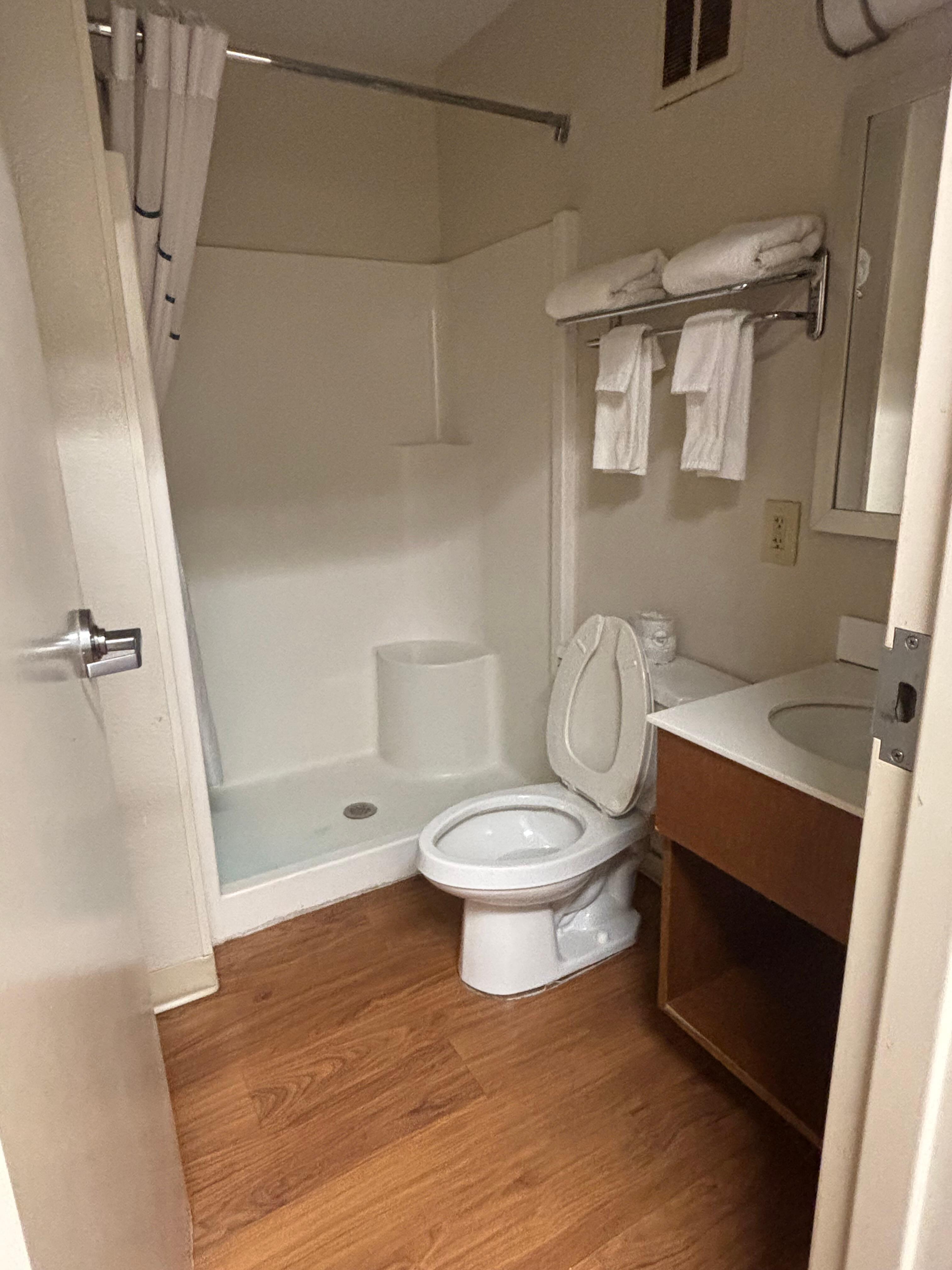 Bathroom with dirty toilet & stained shower