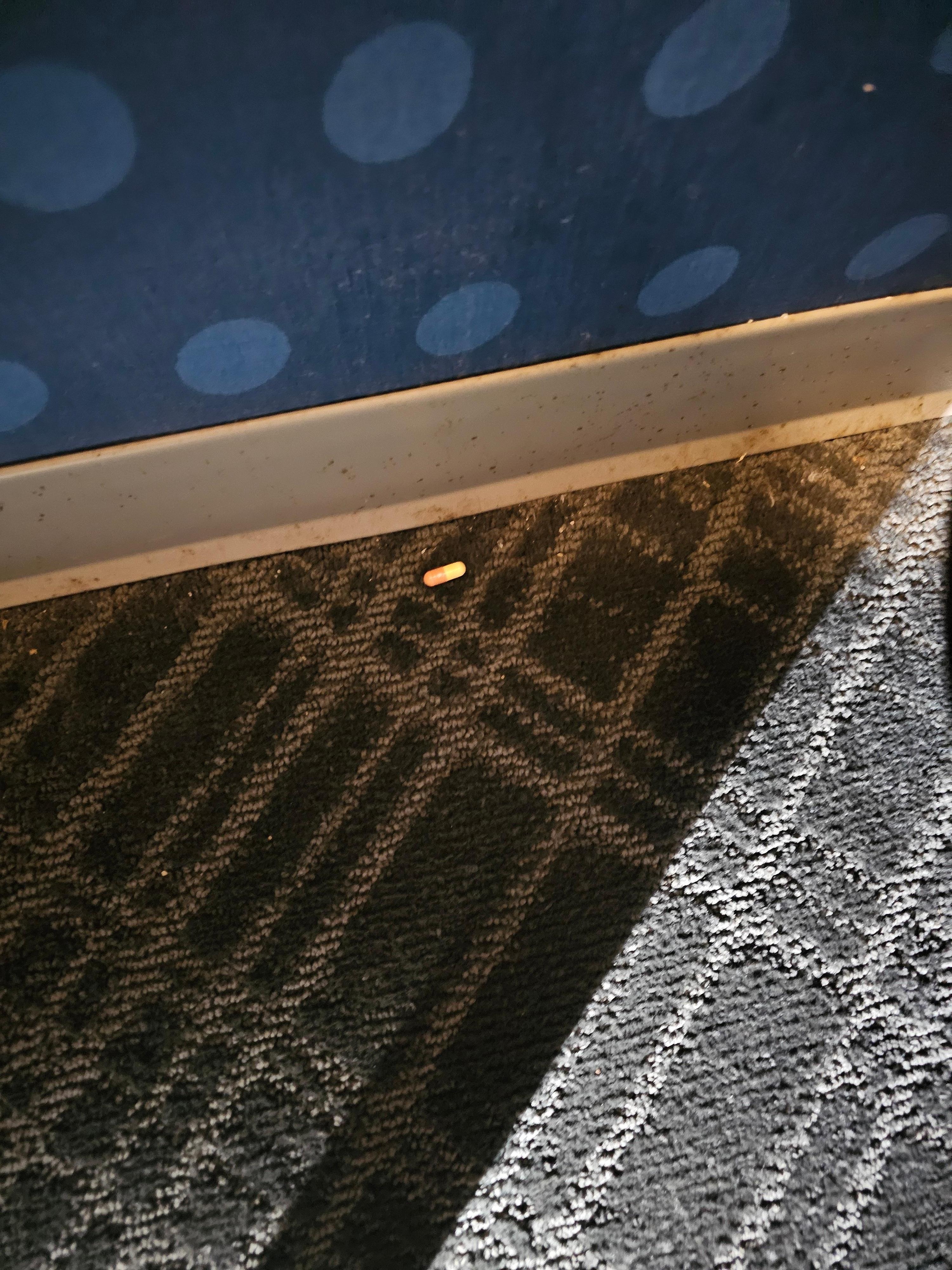 Pill on the floor by headboard