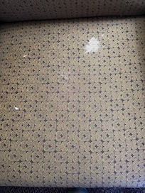 Nasty looking stain on upholstery chair in room. It was bigger and grosser looking than photo portrays it
