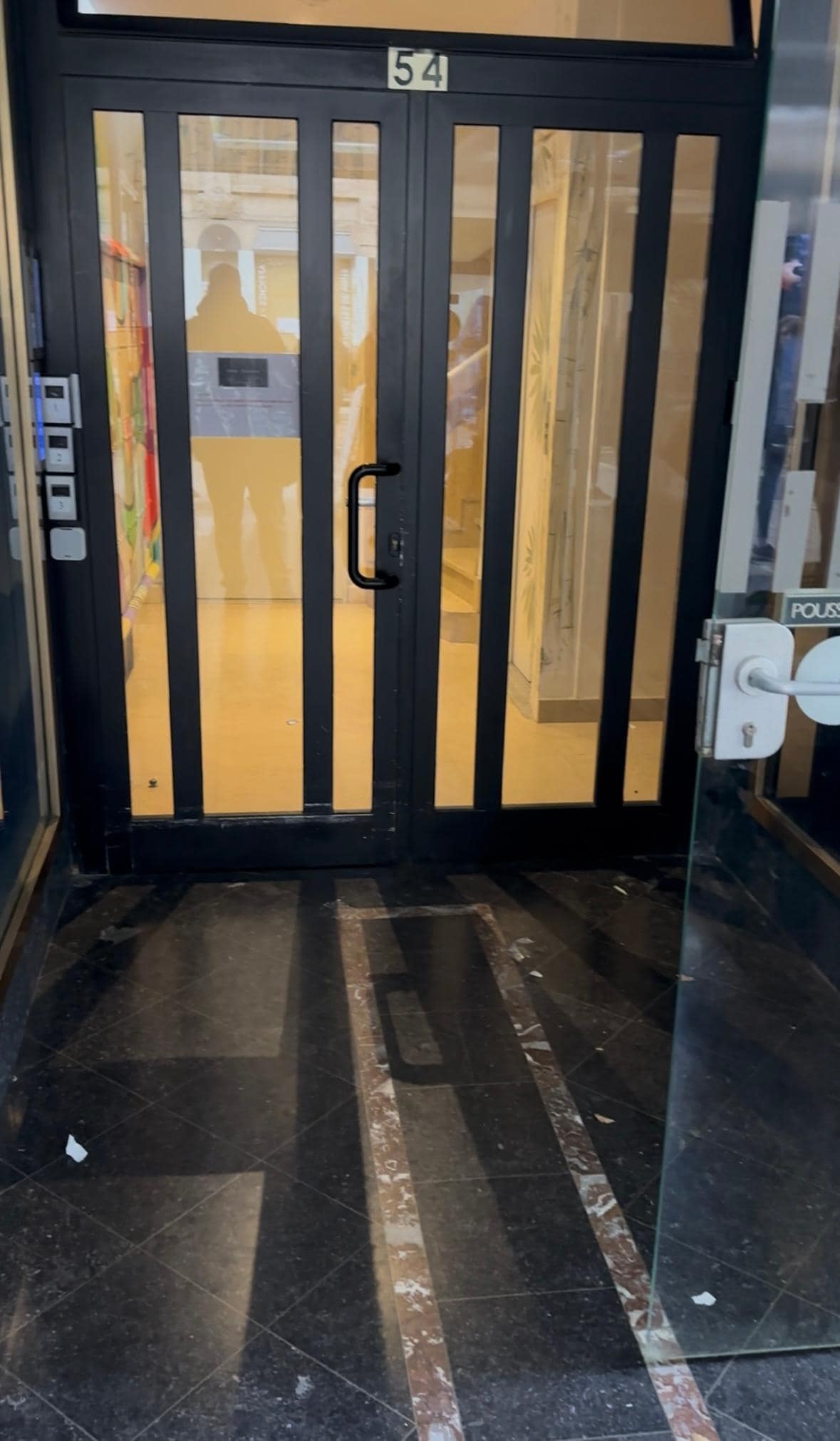 Uninviting entrance, down an alley between two shops.