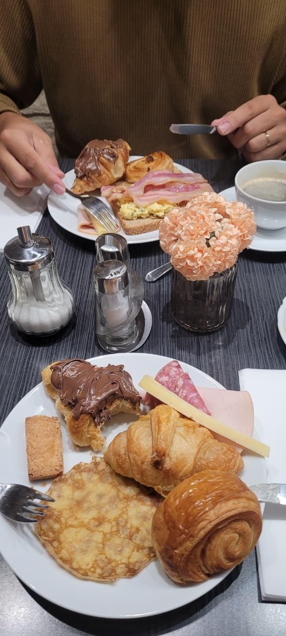 Café da manhã. Algumas opções: queijos, presunto, salame, ovos, bacon, croissaints, pain au chocolat, panqueca de baunilha, sucos, cafés, frutas, iogurtes, etc. 