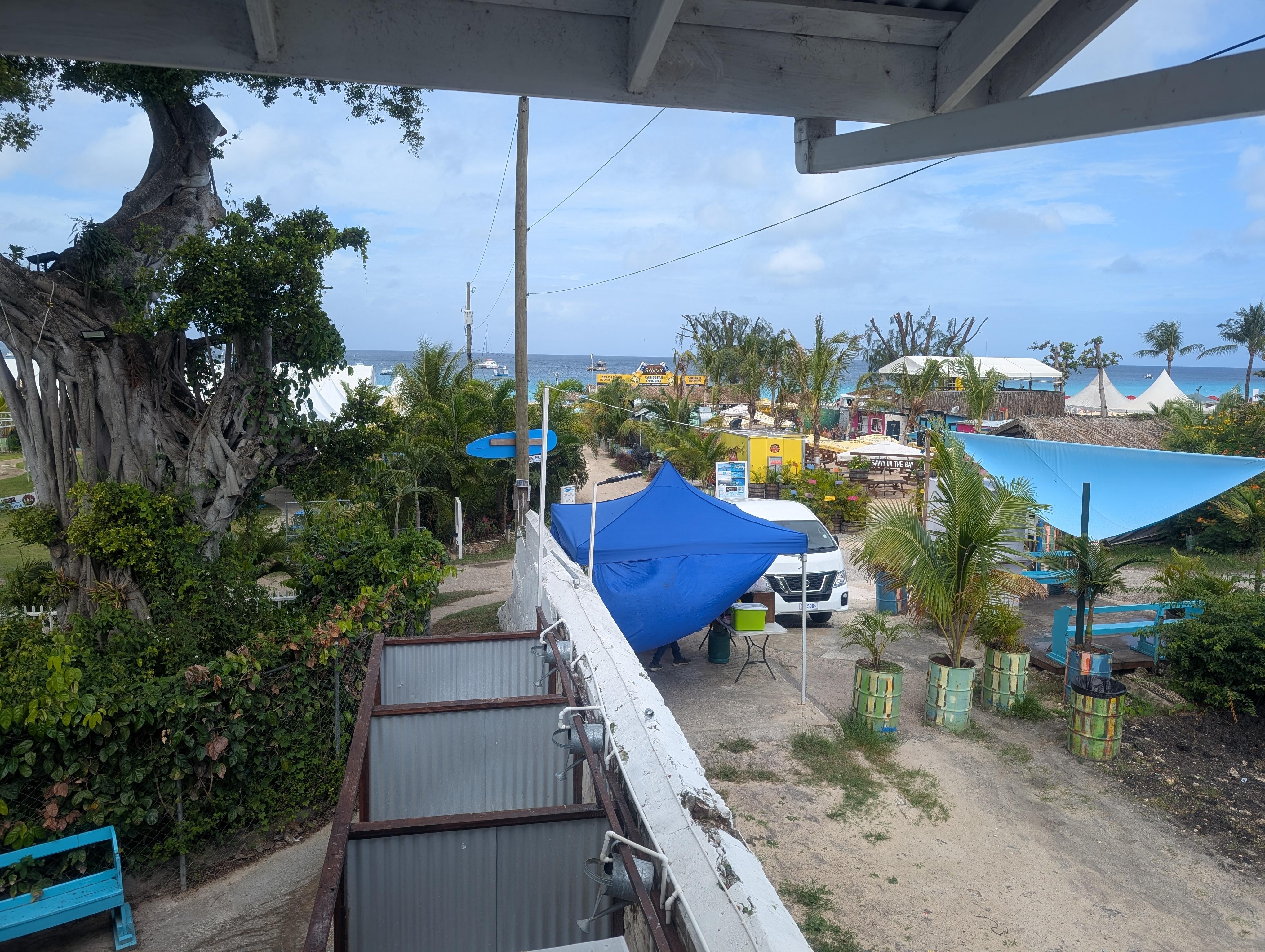 View from the front door to the property: the beach is straight ahead and food is just behind the blue awning.