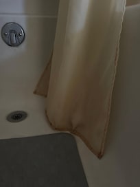 Mildew in curtain from lots of use. Dim light due to bathroom lightbulb need of replacement.