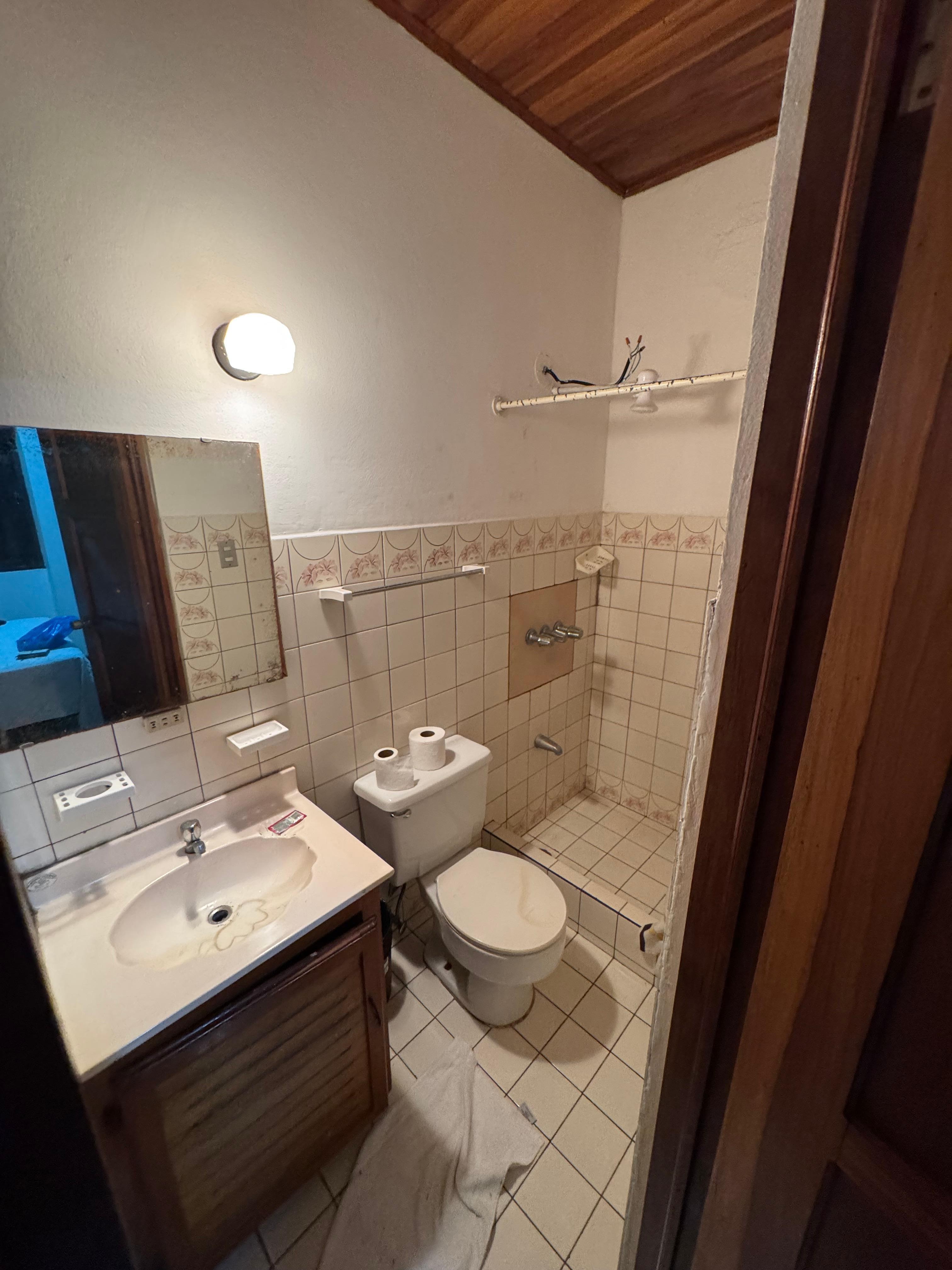 The gross bathroom, with an open shampoo packet someone clearly used as a substitute for the hand soap that wasn't provided.