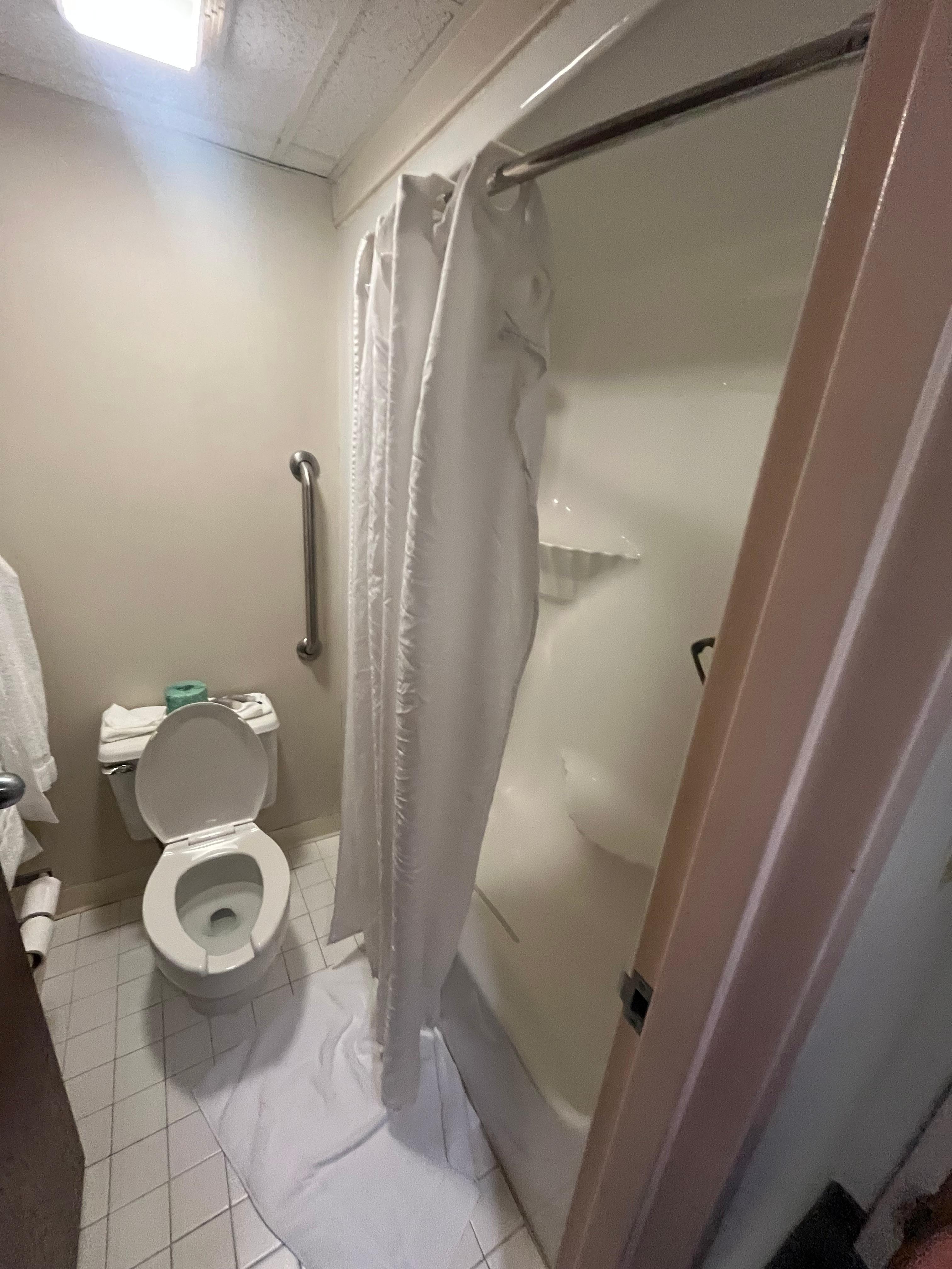 Glass shard/wrapper and hair on bathroom floor 