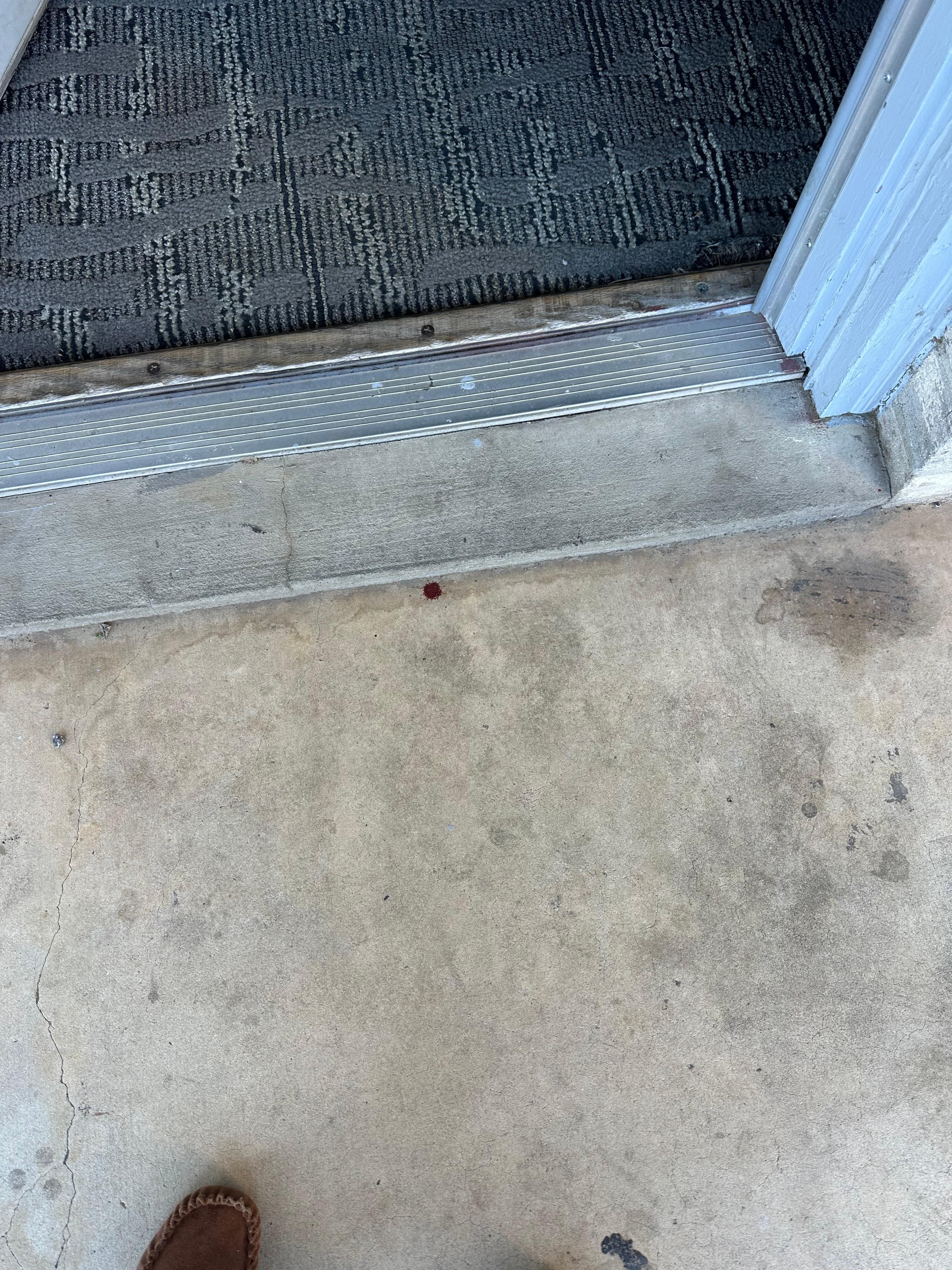 Blood drops on ground outside room 