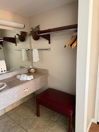 Alcove for suitcase and hanging clothes.