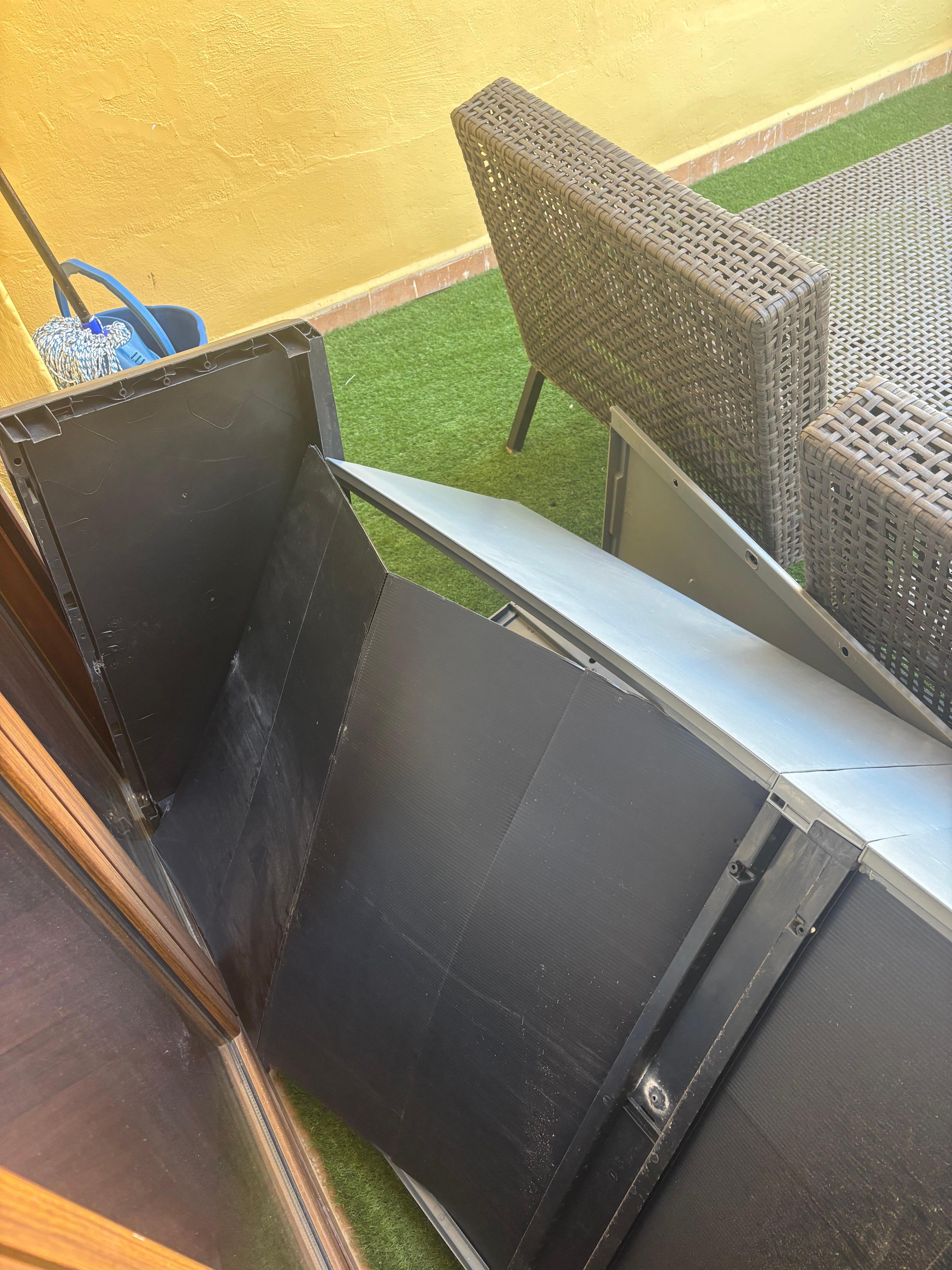 The cabinet on the patio blew over and shattered due to a moderate wind gust 