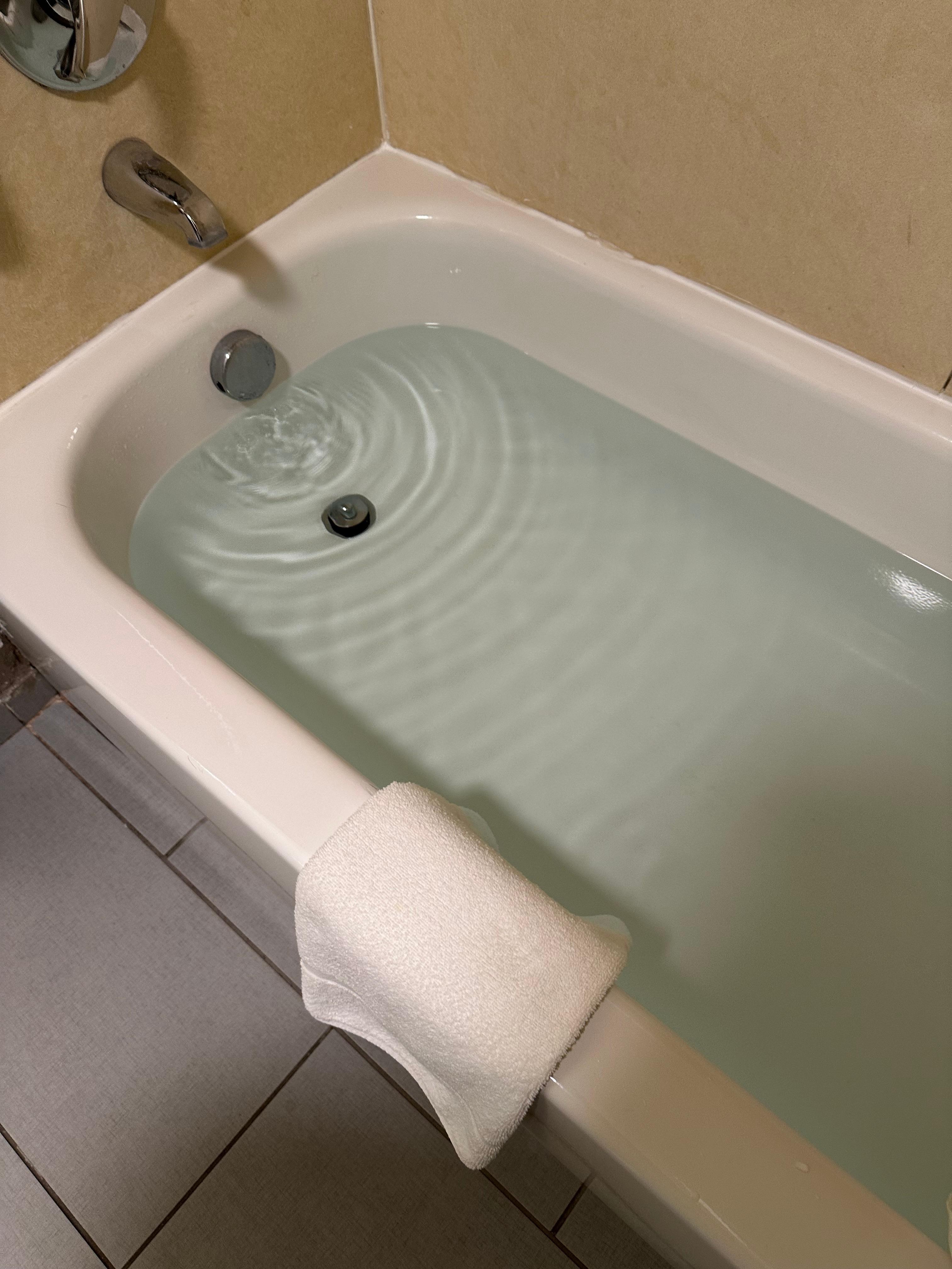 The tub was still full of water, towel soaked, side tub dirty. 