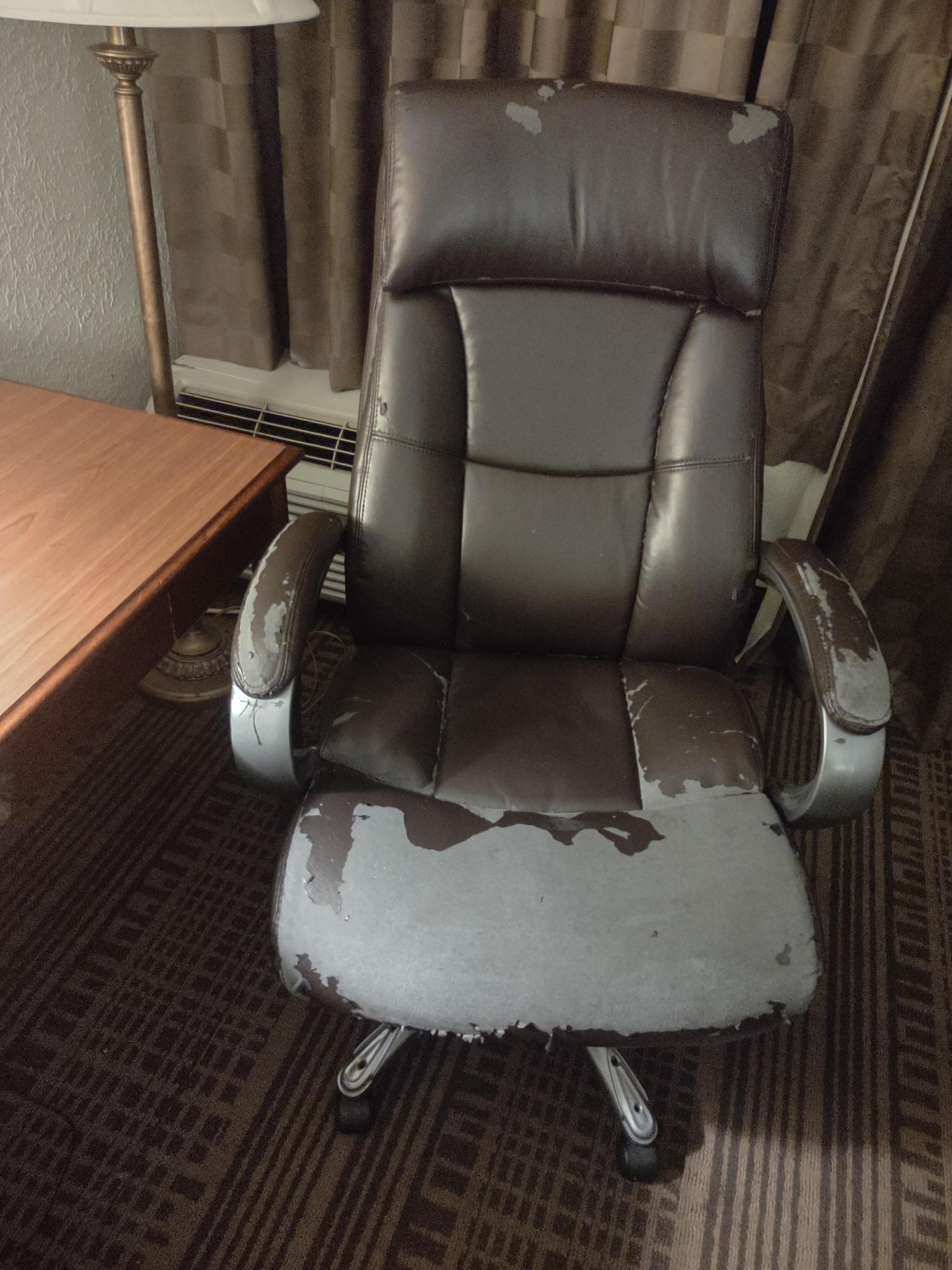 Desk chair in room.  Comfy but trashy.
