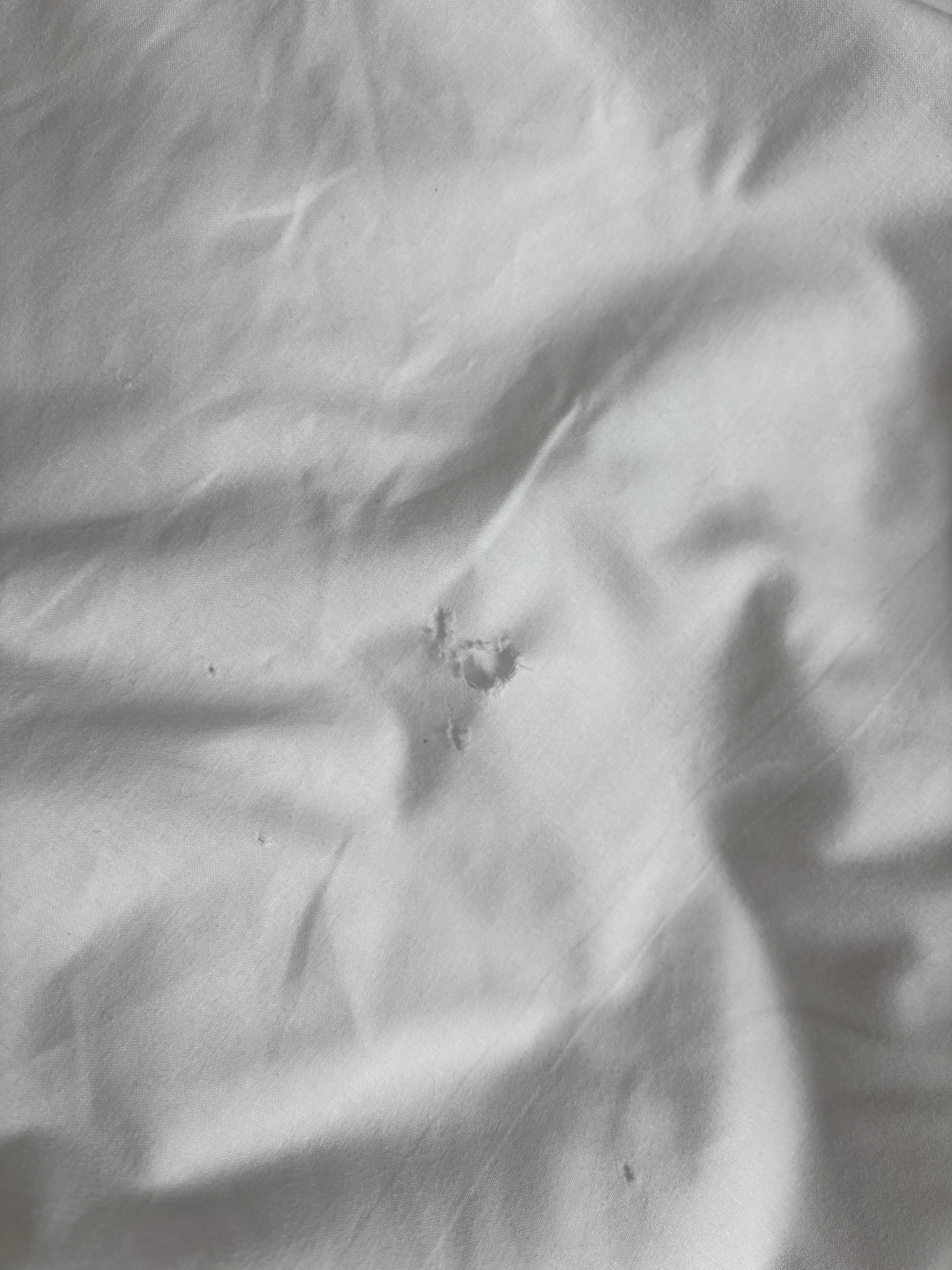 A hole on the bed sheet