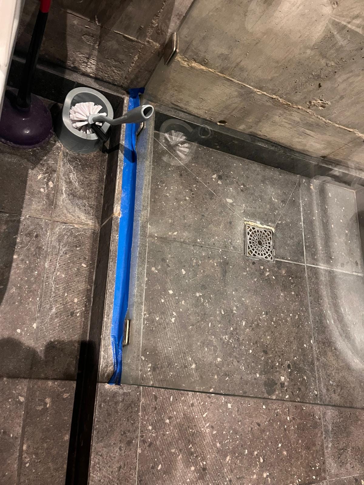 'waterproofing' of shower glass wall at shower curb. Blue duct tape
