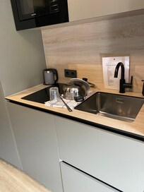 A small kitchen area with cooktop and cookware