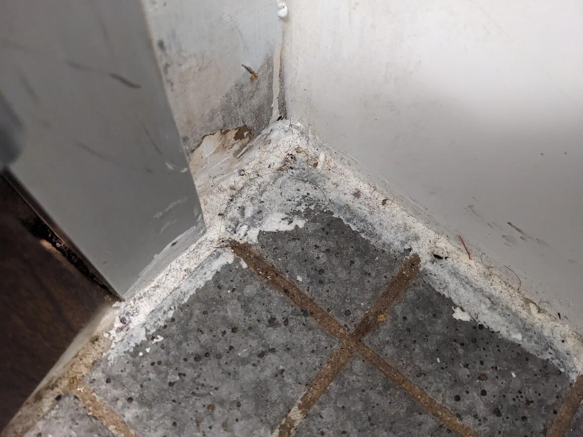 Corner in bathroom where the floor, tub, and wall join.