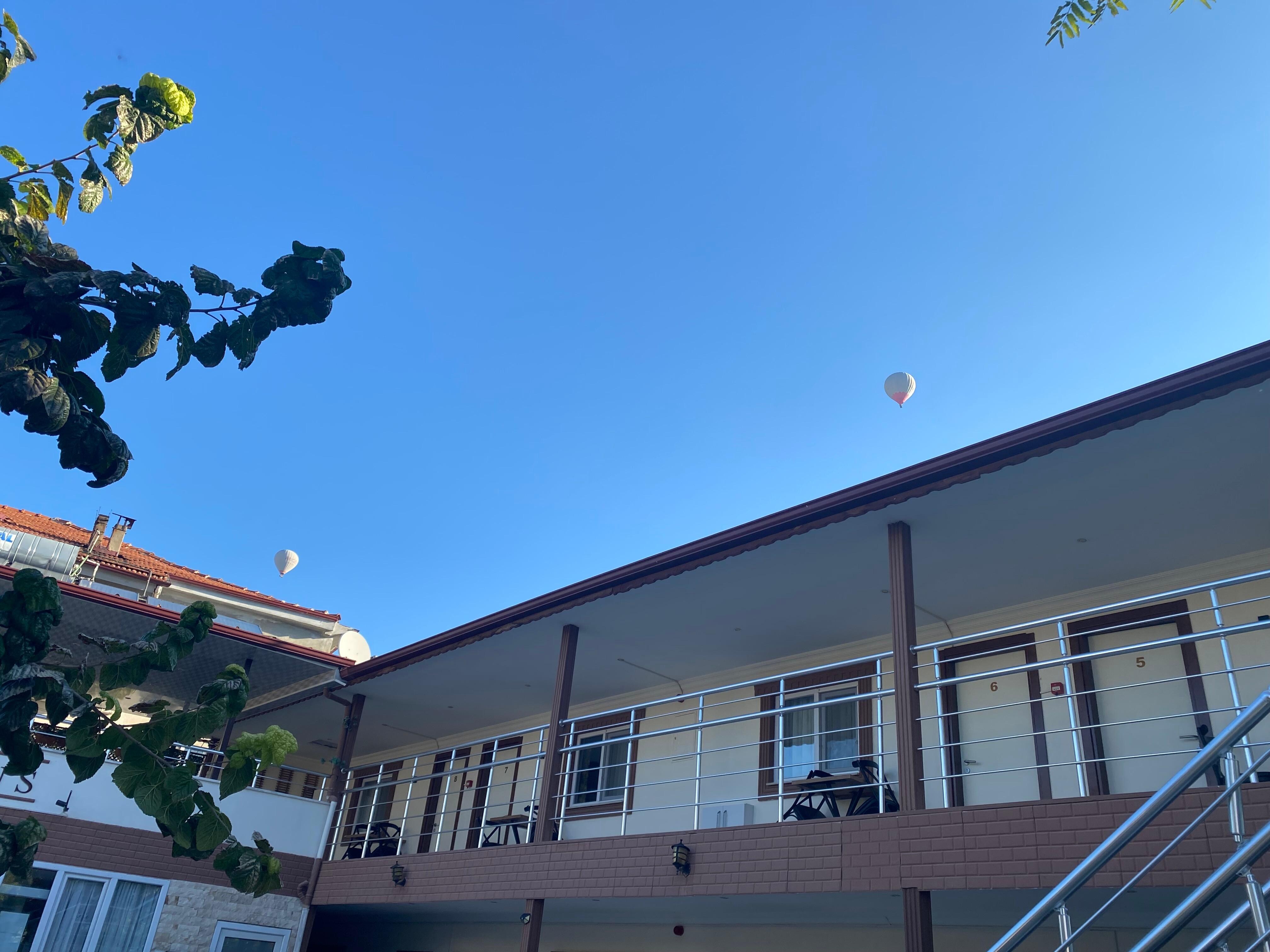 Hot air balloons above hotel