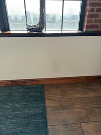 Scuffed and messy wall in the living room. If you zoom in on the floor you can see the random white substance stuck in the grouting.