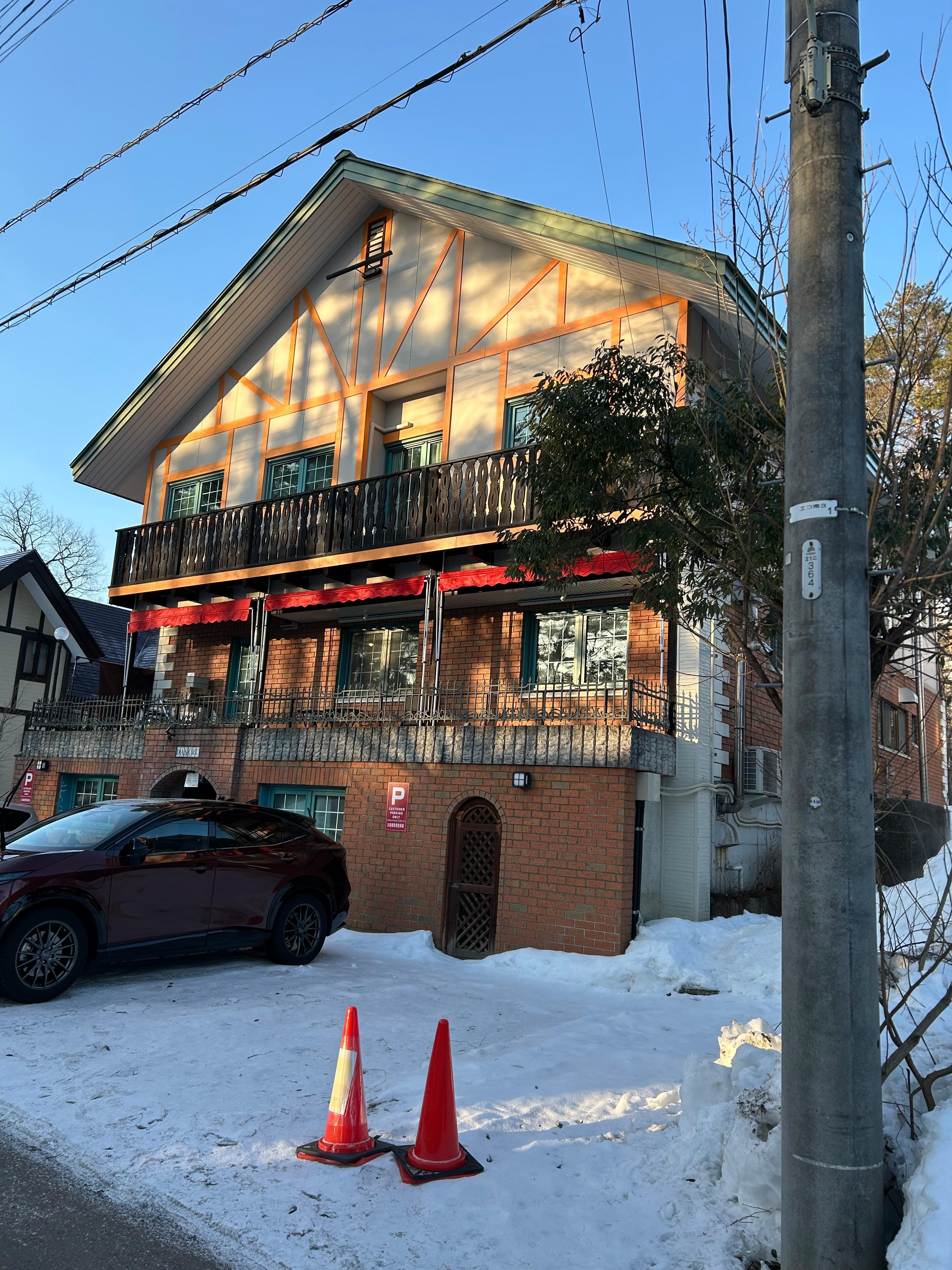View from the street.  The warm room entrance is in front on the lowest floor.  The main entrance is on the far side on the second level.