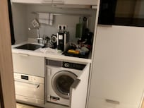 Küche im Zimmer mit Kochmöglichkeiten und Waschtrockner