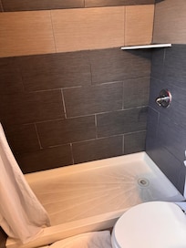 Nasty cramped shower, used to have curved bars, now just a tension rod.