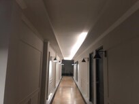 Circulação para os quartos: paredes claras, arandelas, aspecto contemporâneo