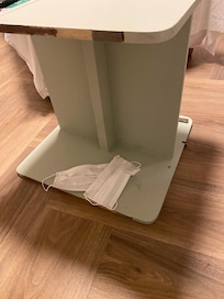 Mesa de cabeceira que tava encostada na parede, máscaras usadas, resto de bolacha e muita sujeira.