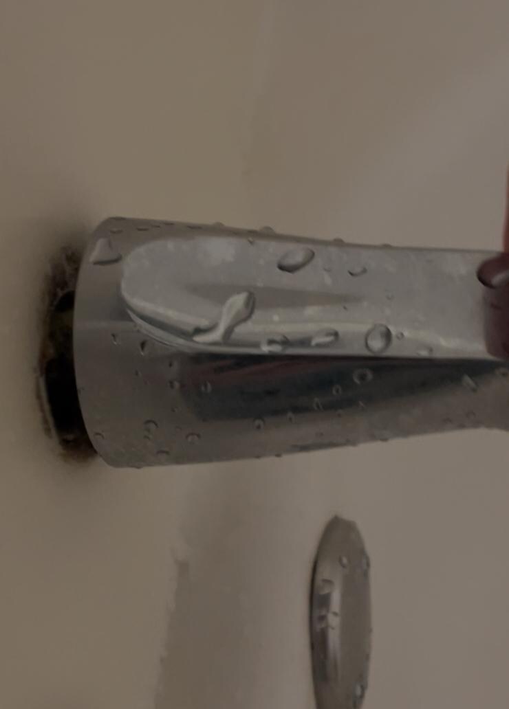 The faucet was not attached to the tub, so you had to hold it still with one hand while you pulled the button up to turn the shower on. 