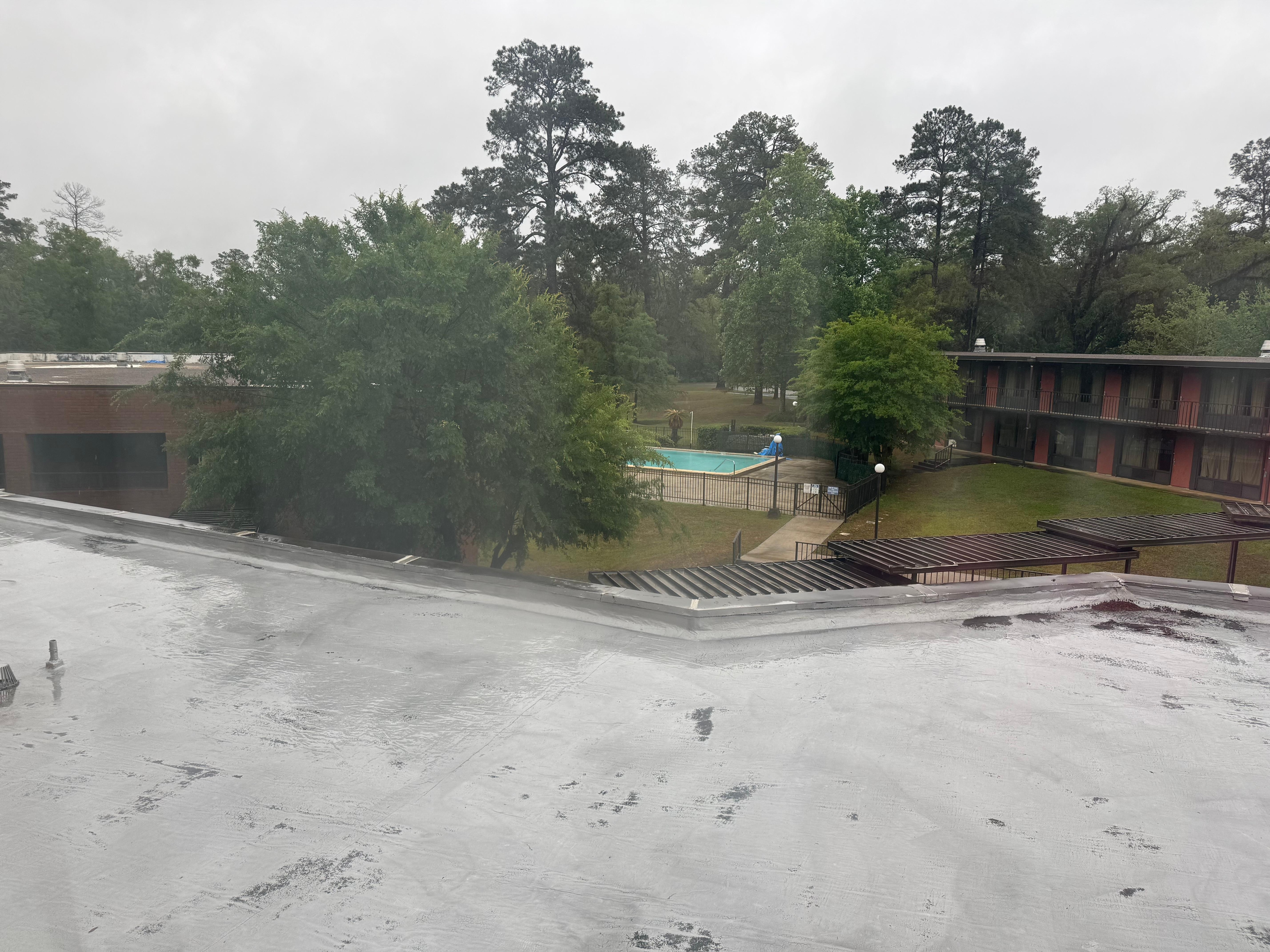 View of abandoned part of hotel rotting roof and unsafe walkway and closed pool 