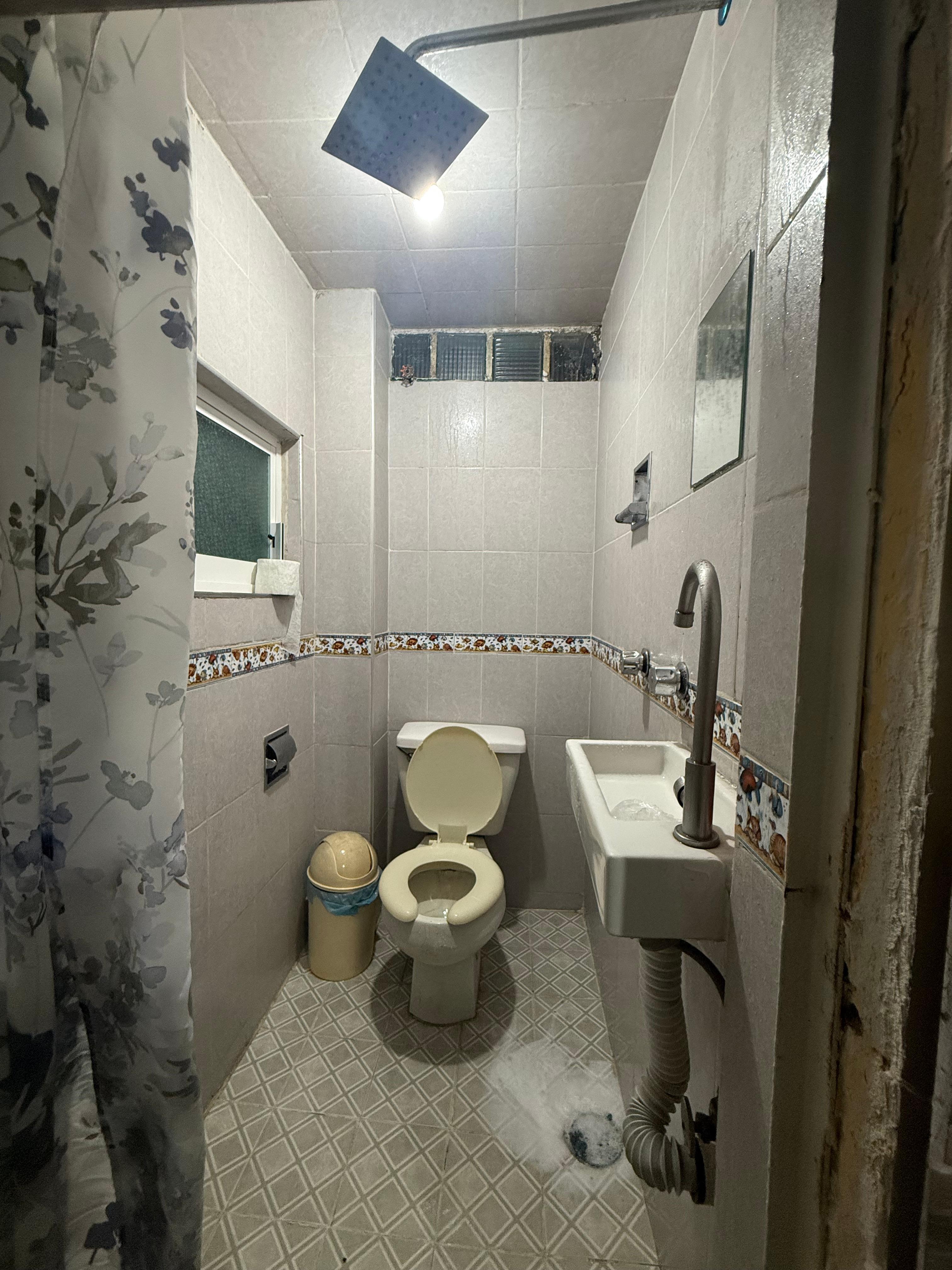 This is the bathroom the shower is over the mini sink and almost you need to shower sitting in the toilet
