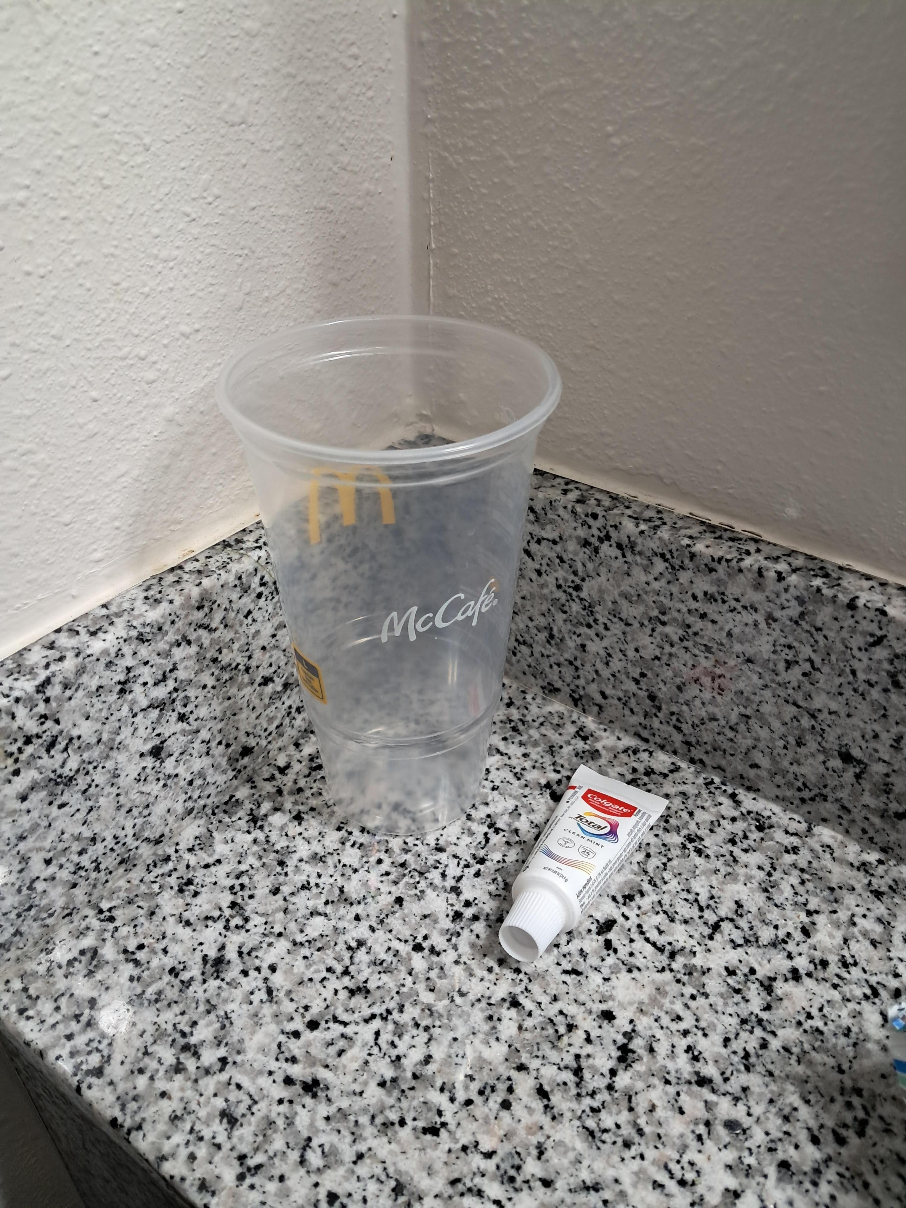 Our small tube of toothpaste beside the cup