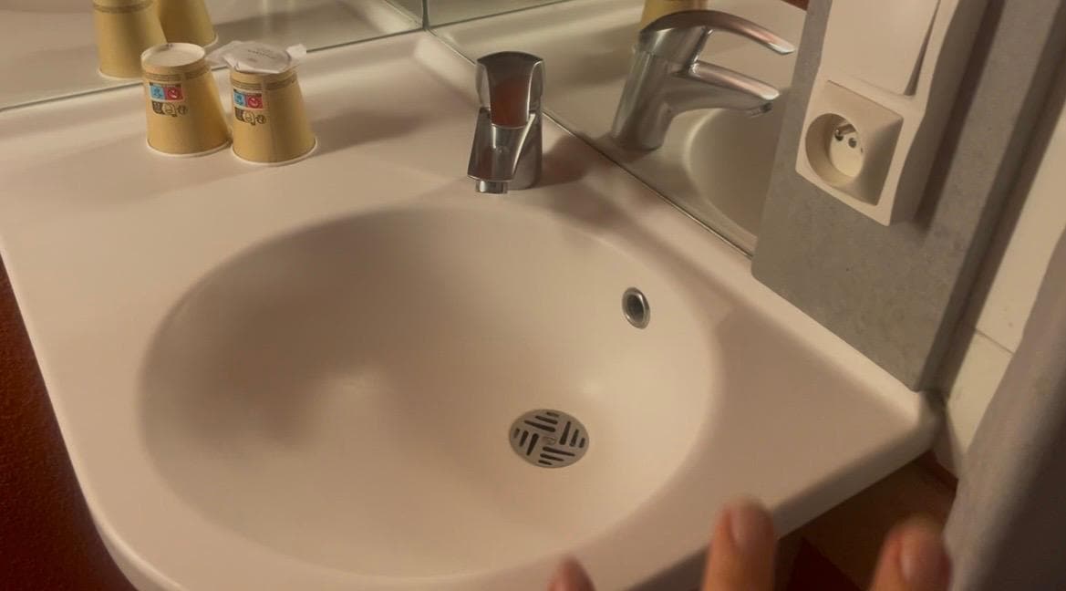 Essa pia fica do lado de fora do banheiro, do outro lado do quarto, ao lado da janela.