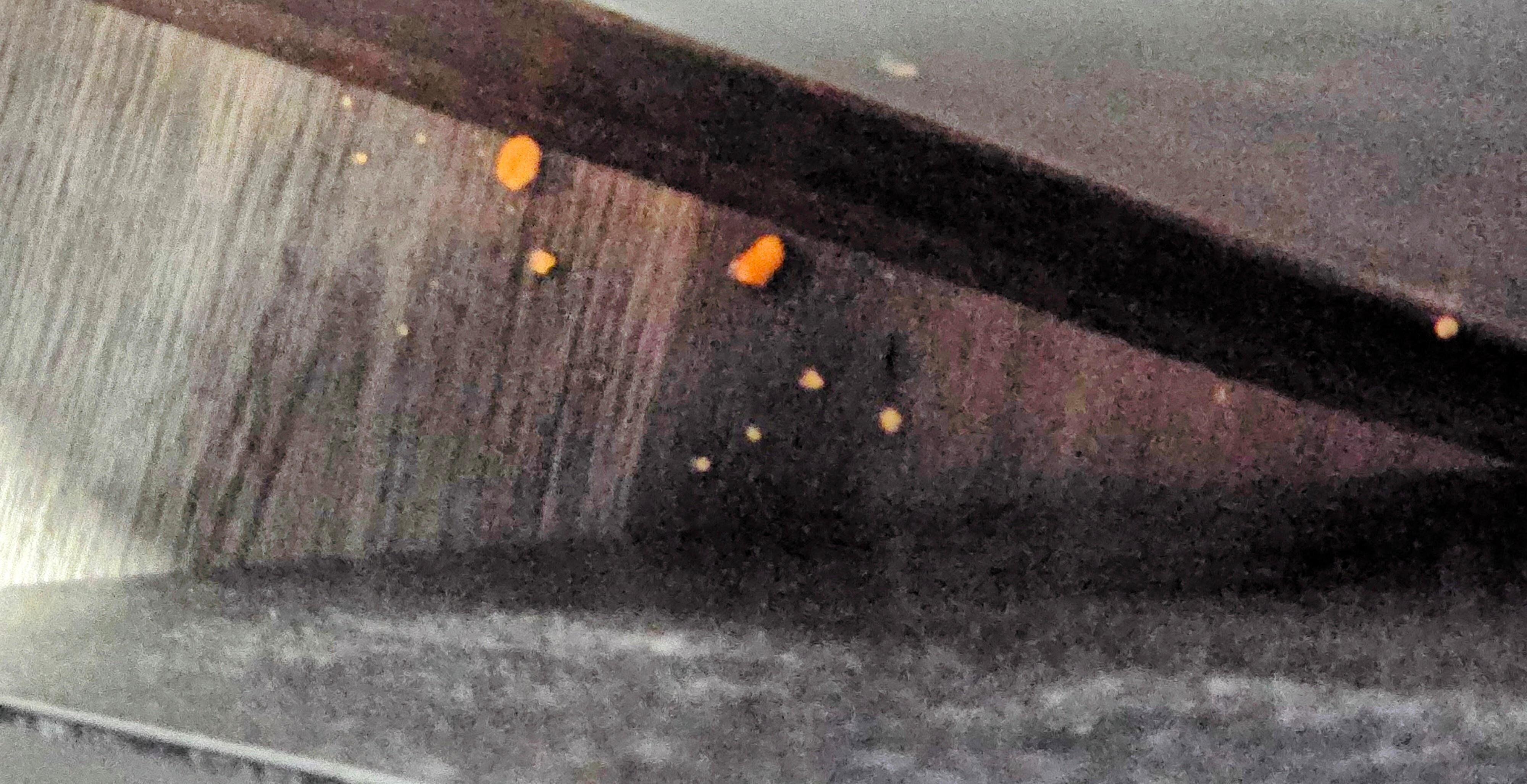 Chips on floor beside refrigerator visible, not behind it, on the side. 