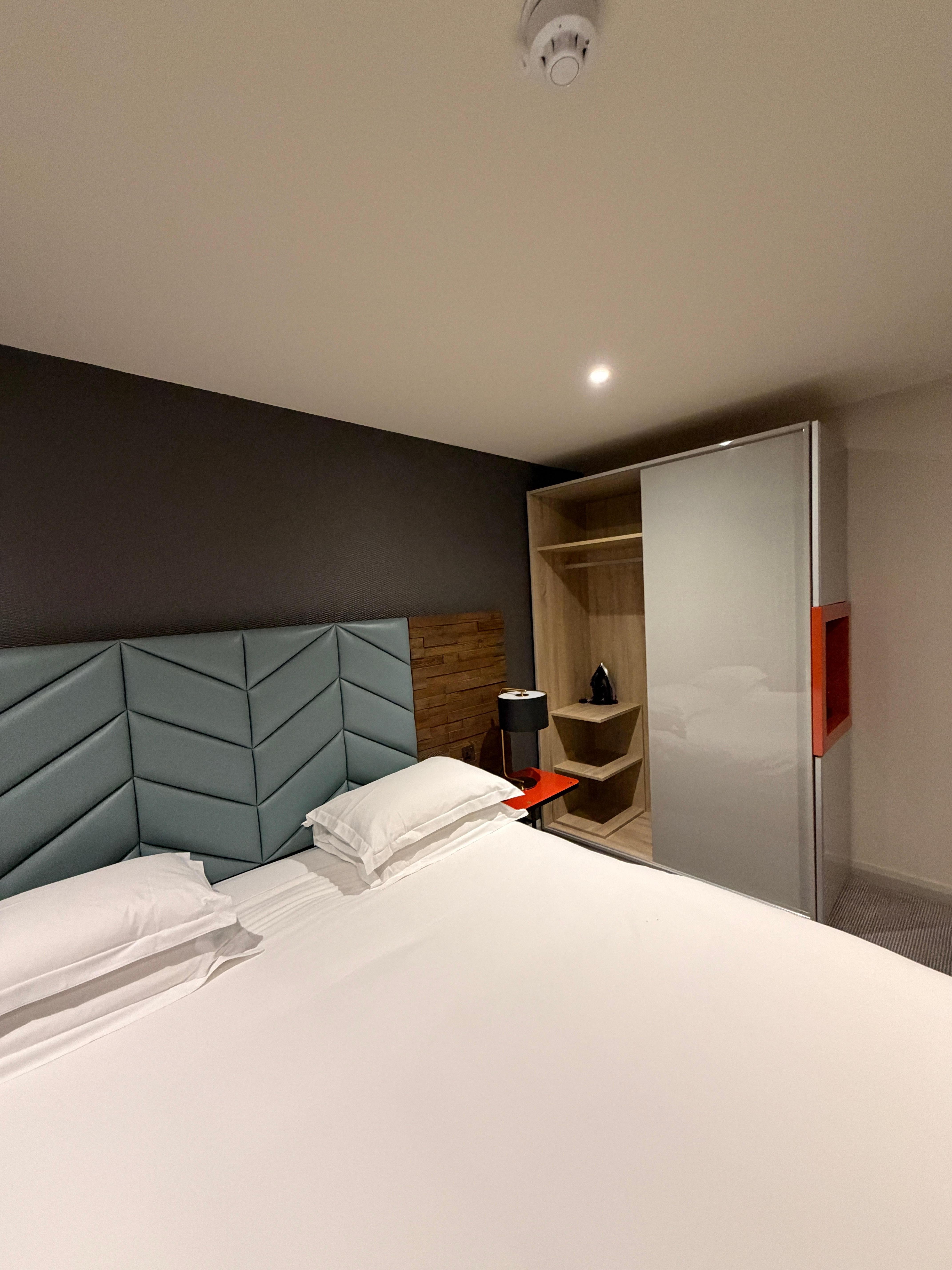 Storage closet with iron and ironing board.