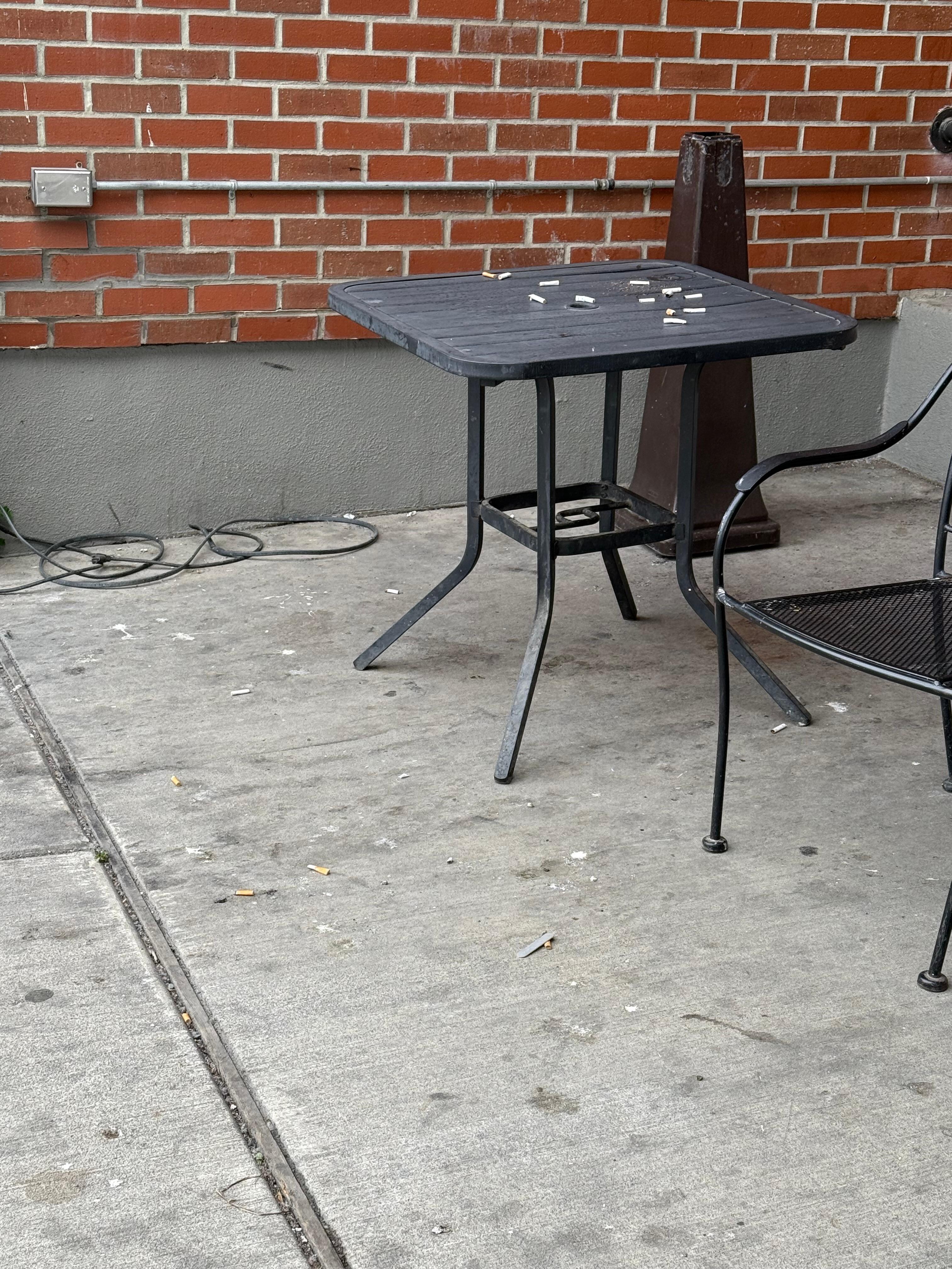 Smoking area with butts everywhere and right next to the front doors!
