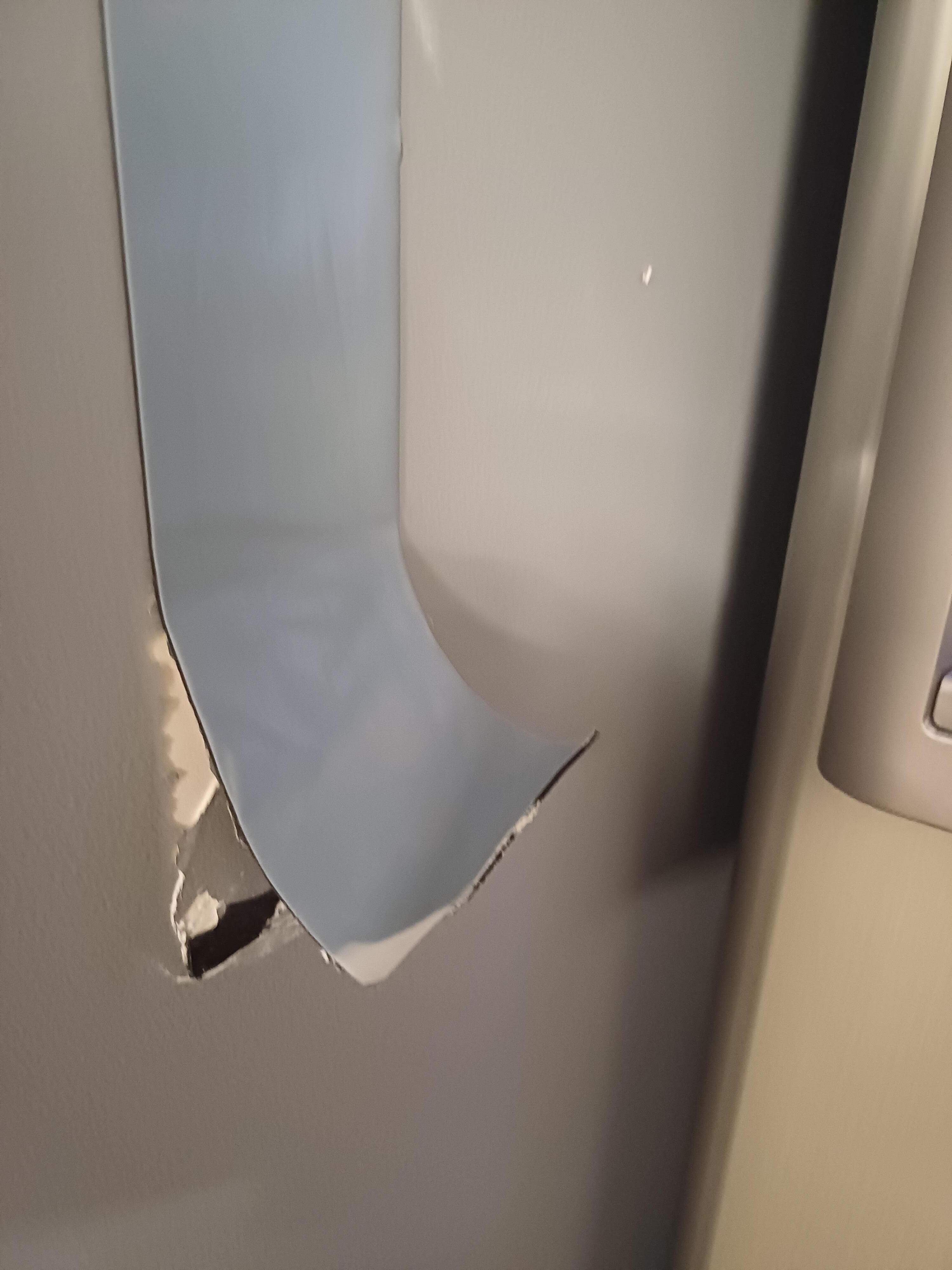 tape next to fridge on wall peeling off