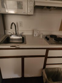 The kitchen area is worn down, no pots, pans, dish towels etc.