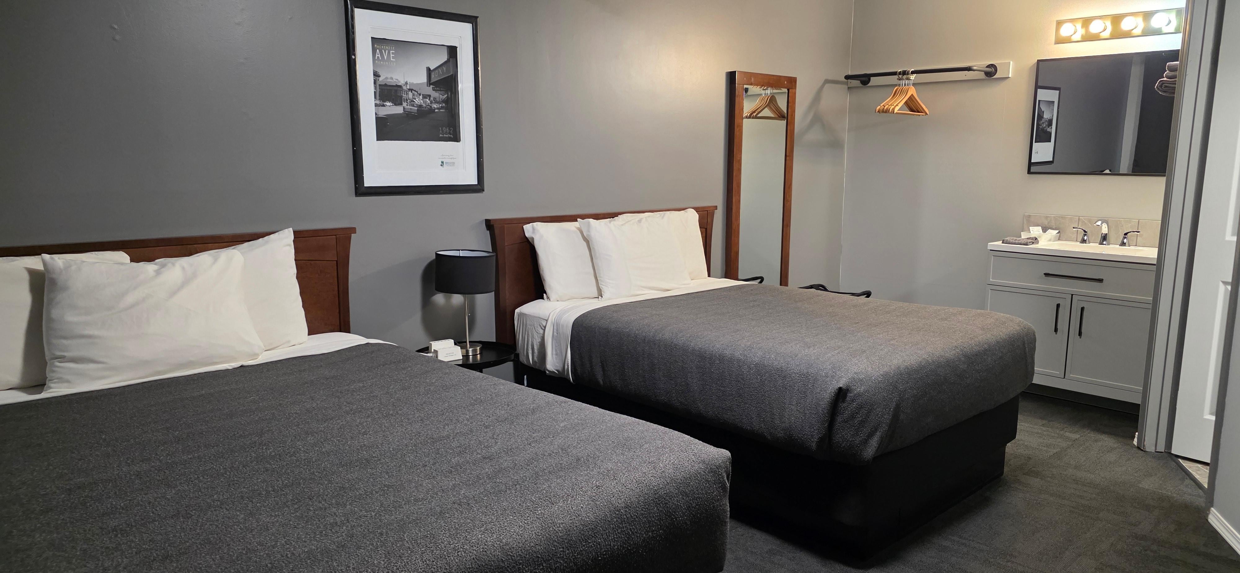 View of two queen beds and sink.