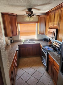 Fully stocked kitchen: Fridge, stove, microwave, coffee maker, dishwasher, garbage disposer, pots, pans, plates, bowls, cups, silverware, paper towels