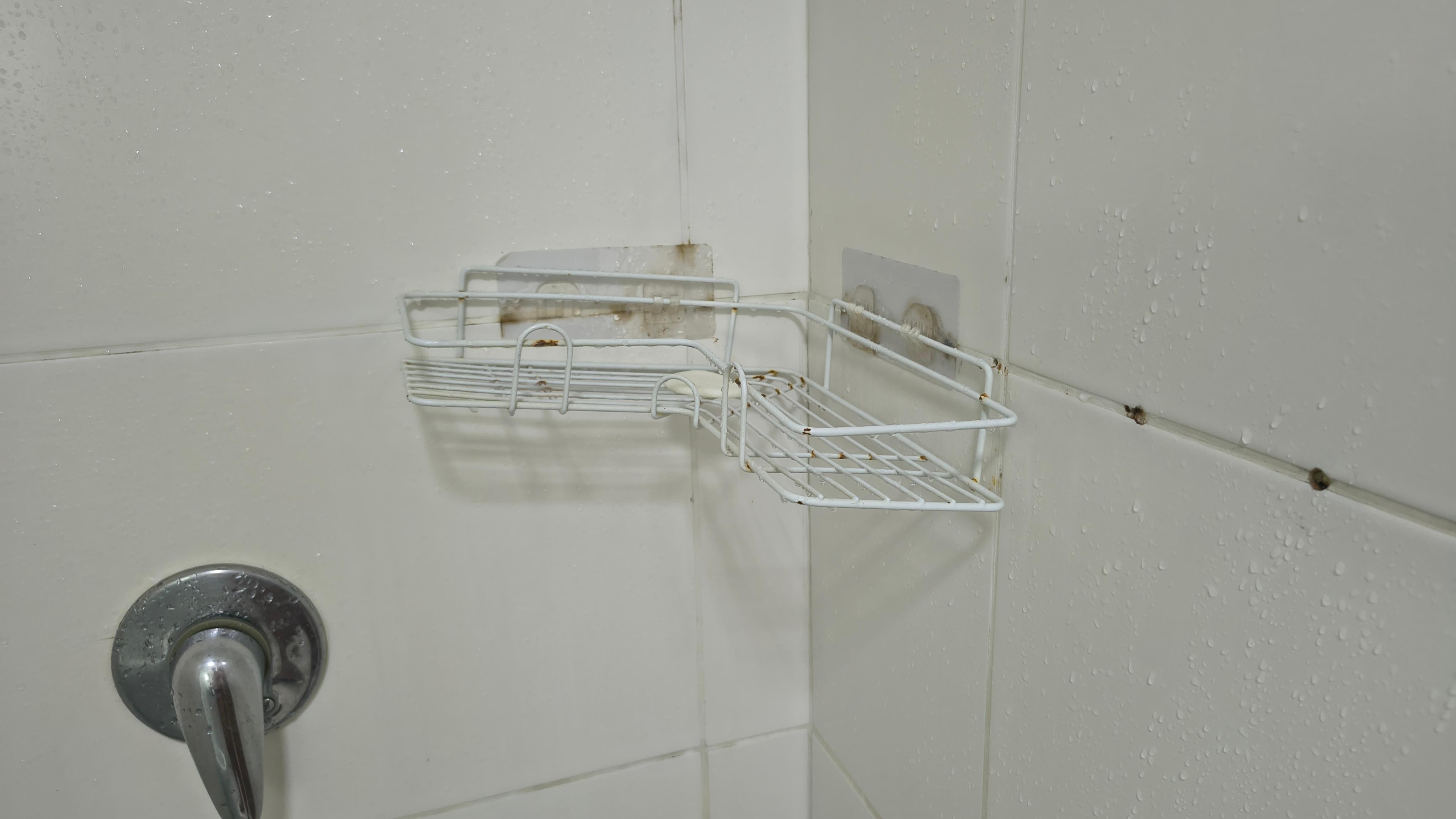 O Suporte de sabonete enferrujado e torto.