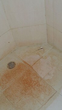 Banheiro com piso descascando e manchado