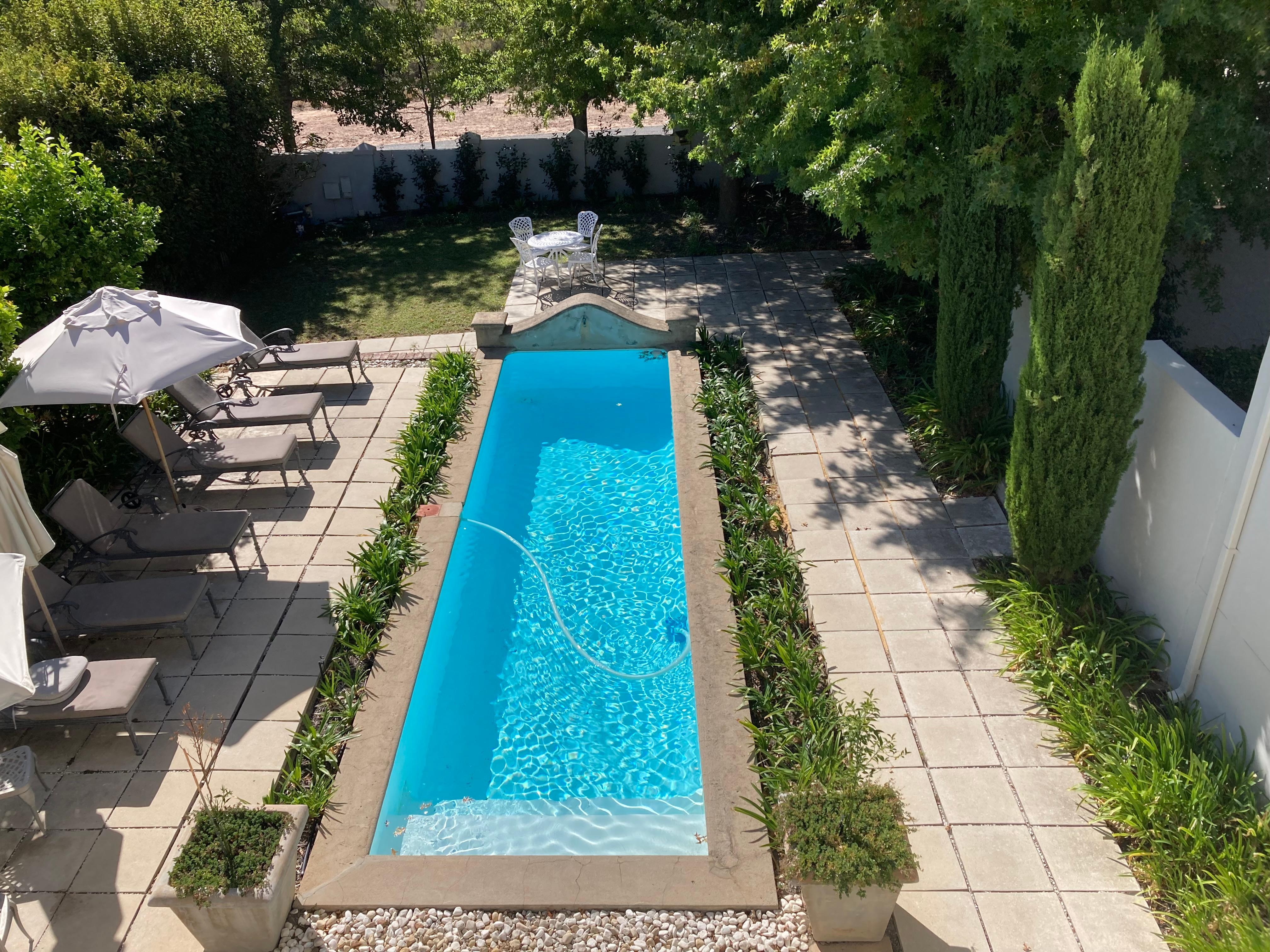This is the lovely pool and patio area with chairs and umbrellas.