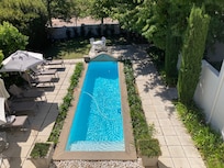 This is the lovely pool and patio area with chairs and umbrellas.