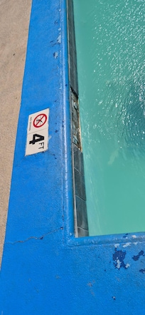 Deck chair at bottom of pool like a dump.