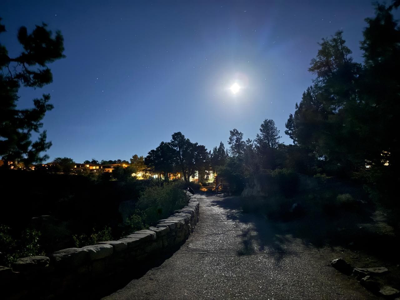 Vista noturna do restaurante e quarto com a trilha de caminhada na beira do Canyon