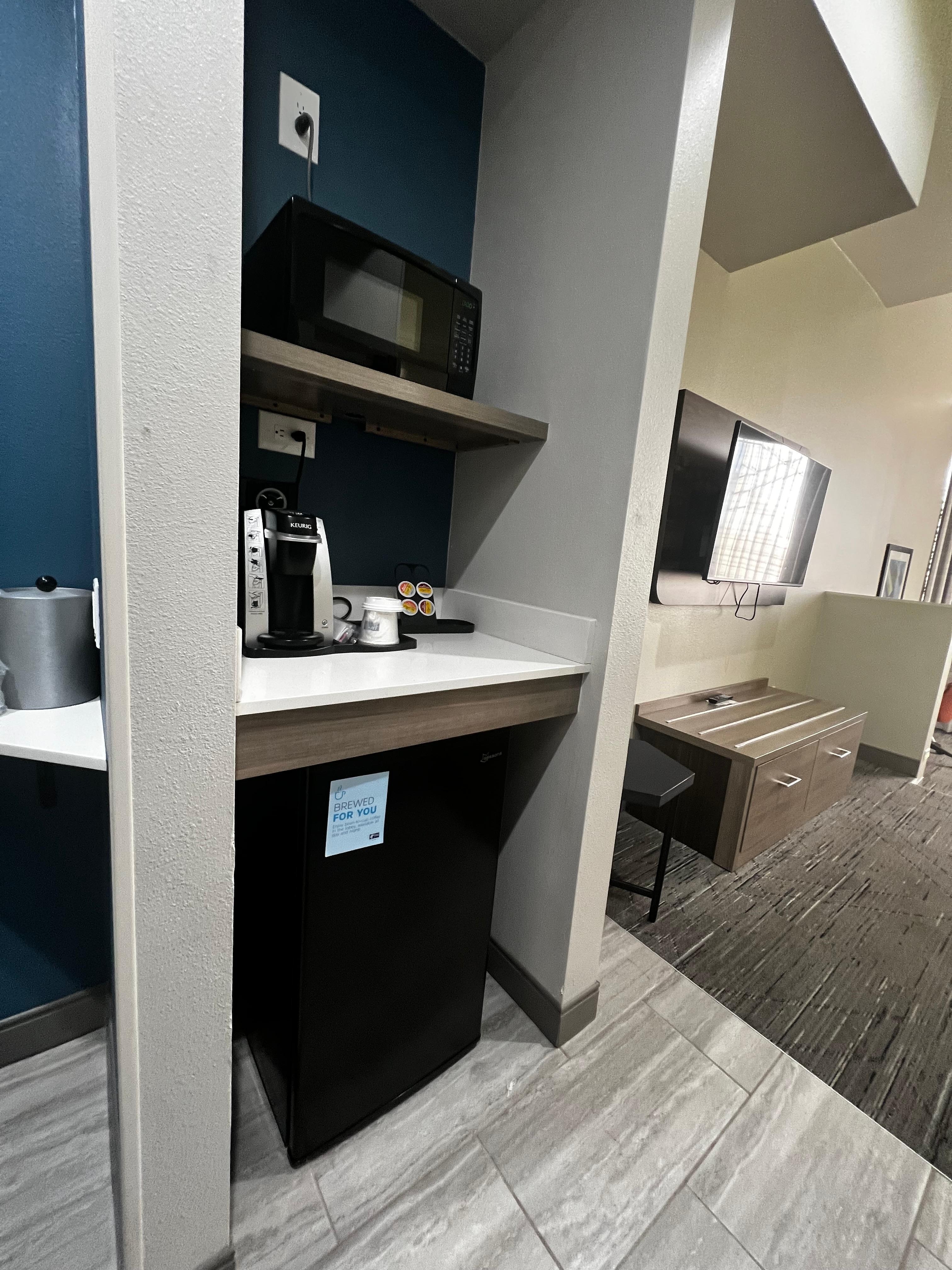 Small “kitchen” area with refrigerator, microwave, coffee maker.