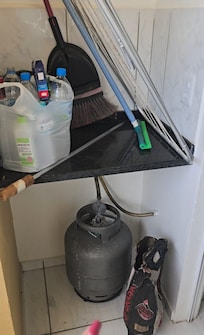 A vassoura, a pá e o varal são empilhados nesse canto