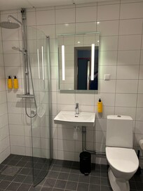 Ett rent och snyggt på toaletten med dusch.