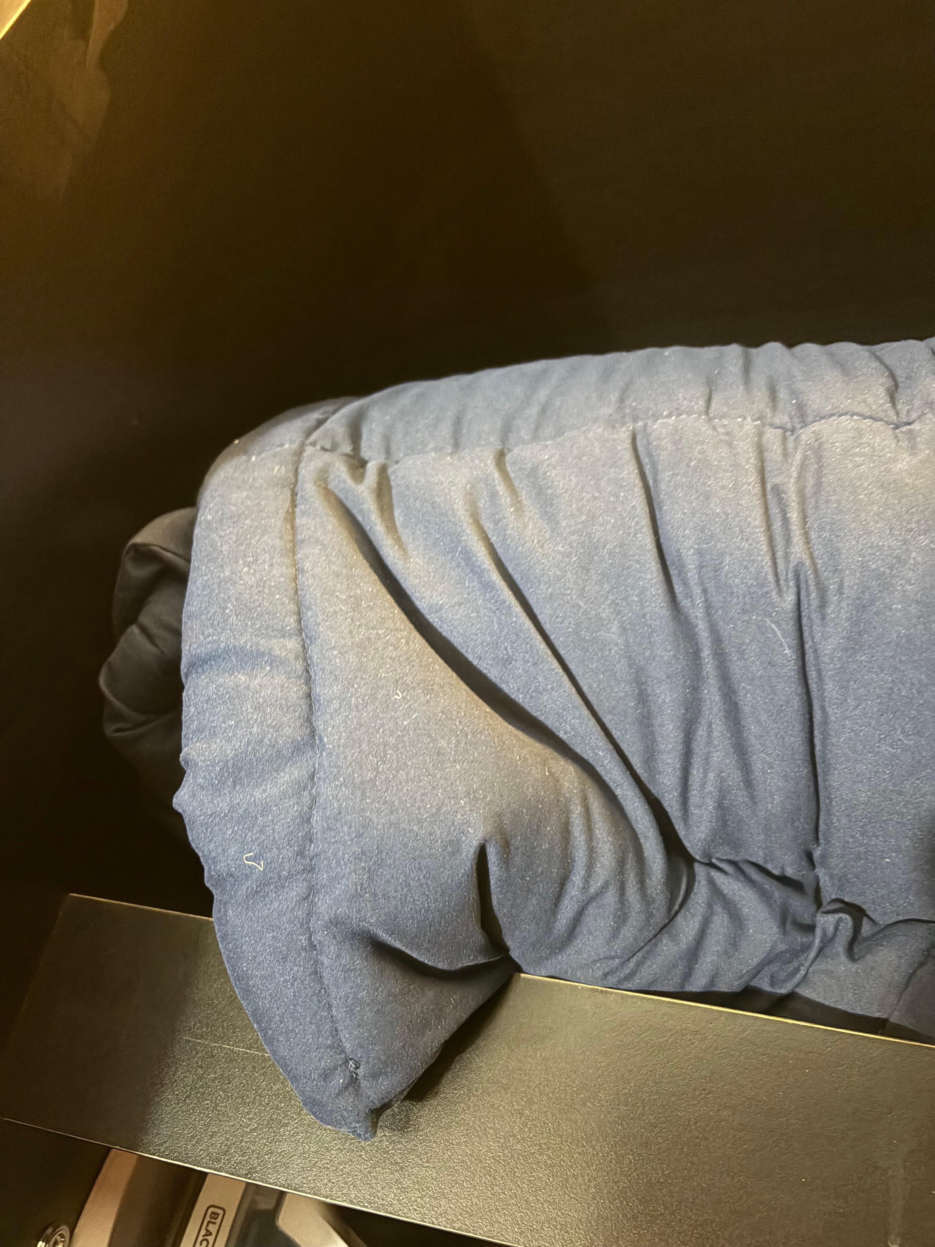 Dirty blanket rolled up, not even folded. 